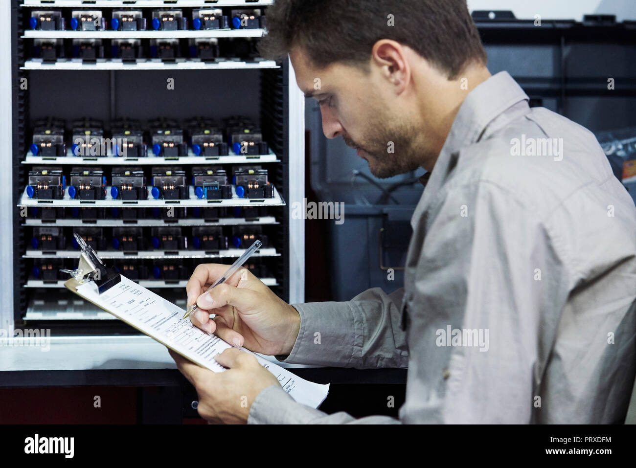 Engineer filling document in office Stock Photo - Alamy