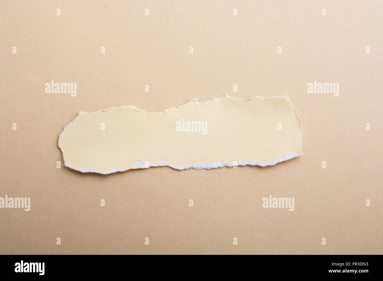 Little torn paper seen on a sheet of paper Stock Photo - Alamy