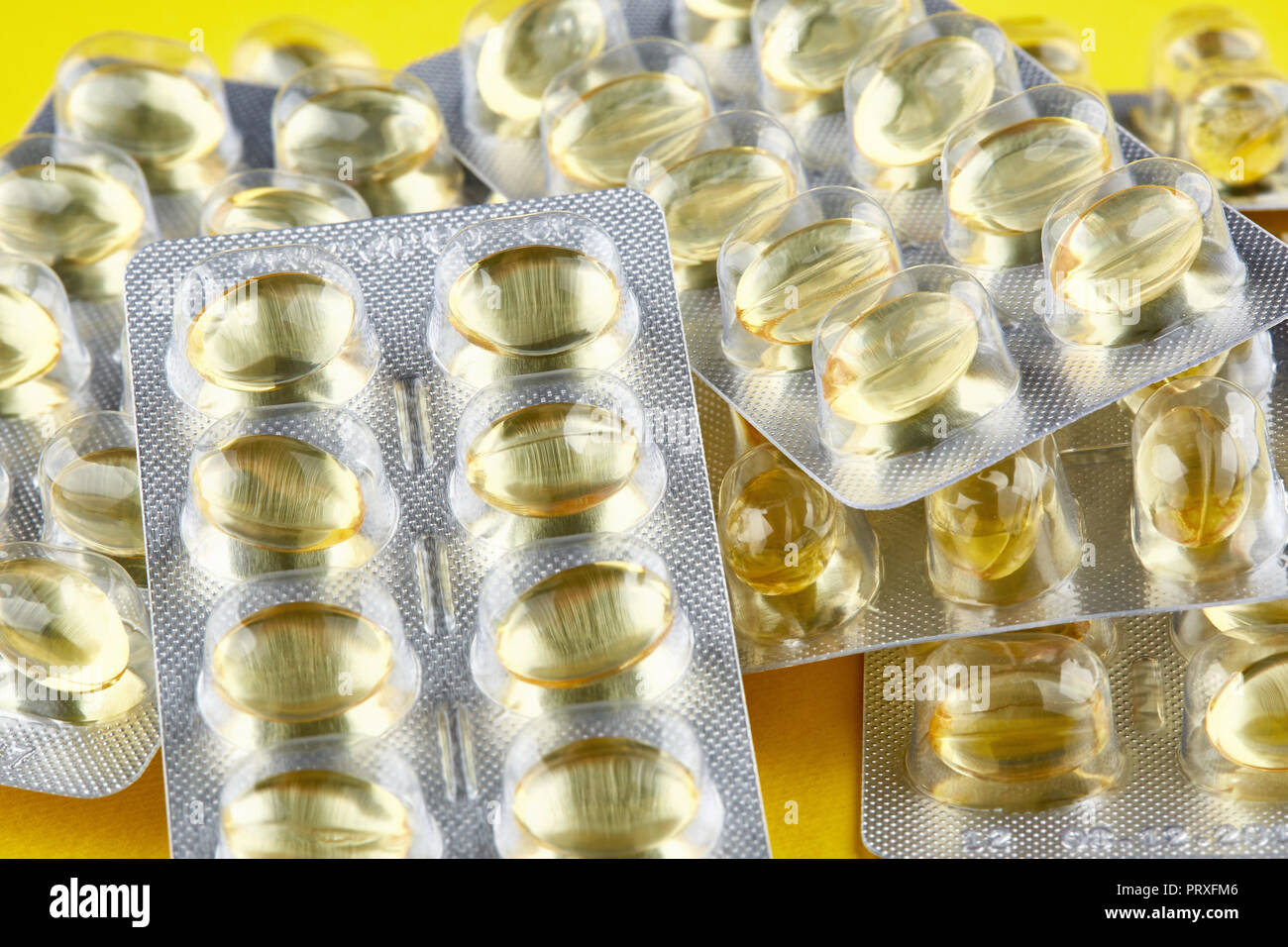 Sealed packages with transparent capsules on yellow background ...