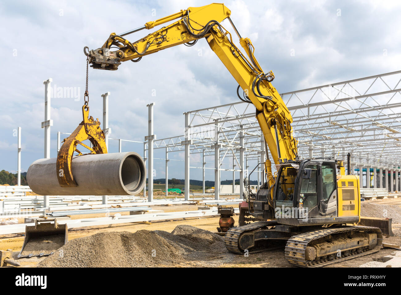 construction site excavator with a concrete pipe Stock Photo - Alamy