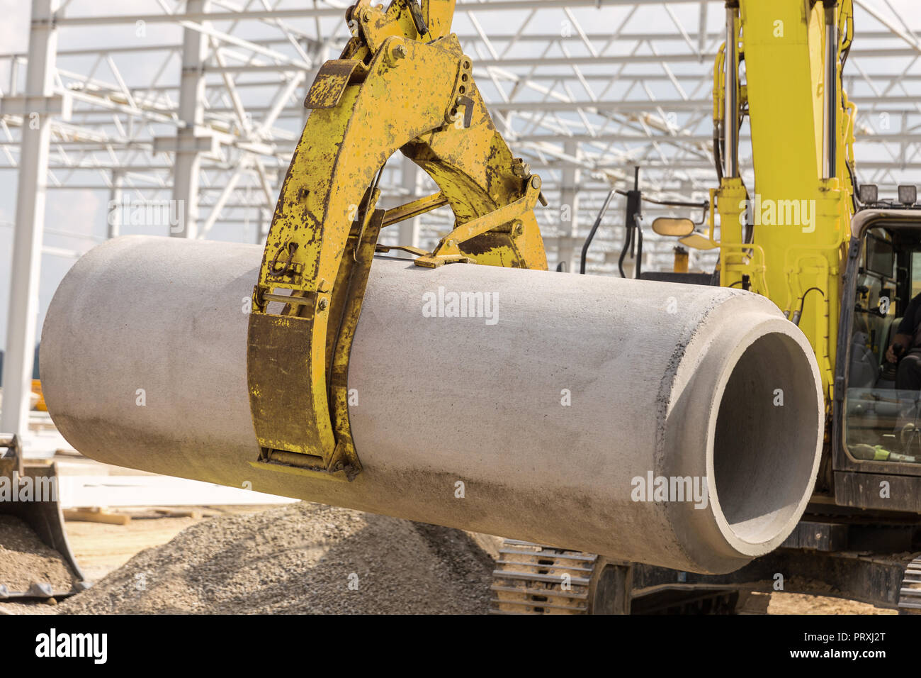 construction site excavator with a concrete pipe Stock Photo - Alamy
