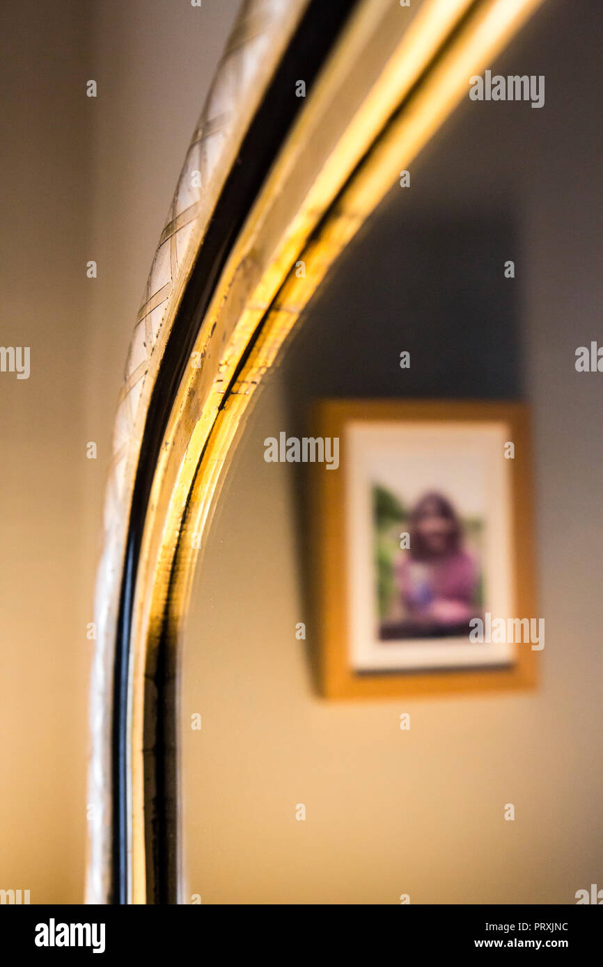 Reflections of photos,other mirrors and the interior of a house in a ...