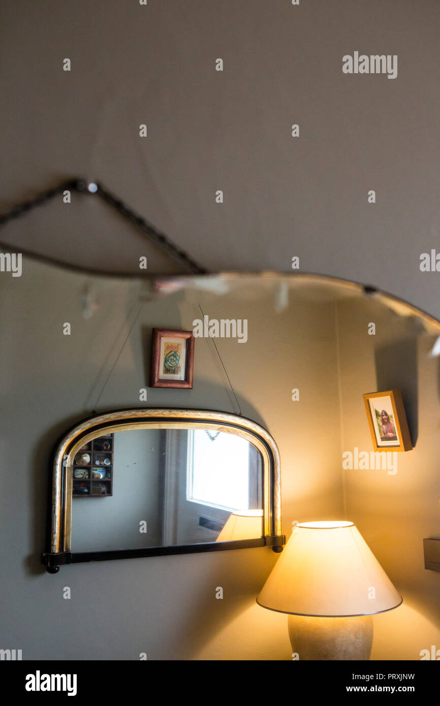 Reflections of photos,other mirrors and the interior of a house in a ...