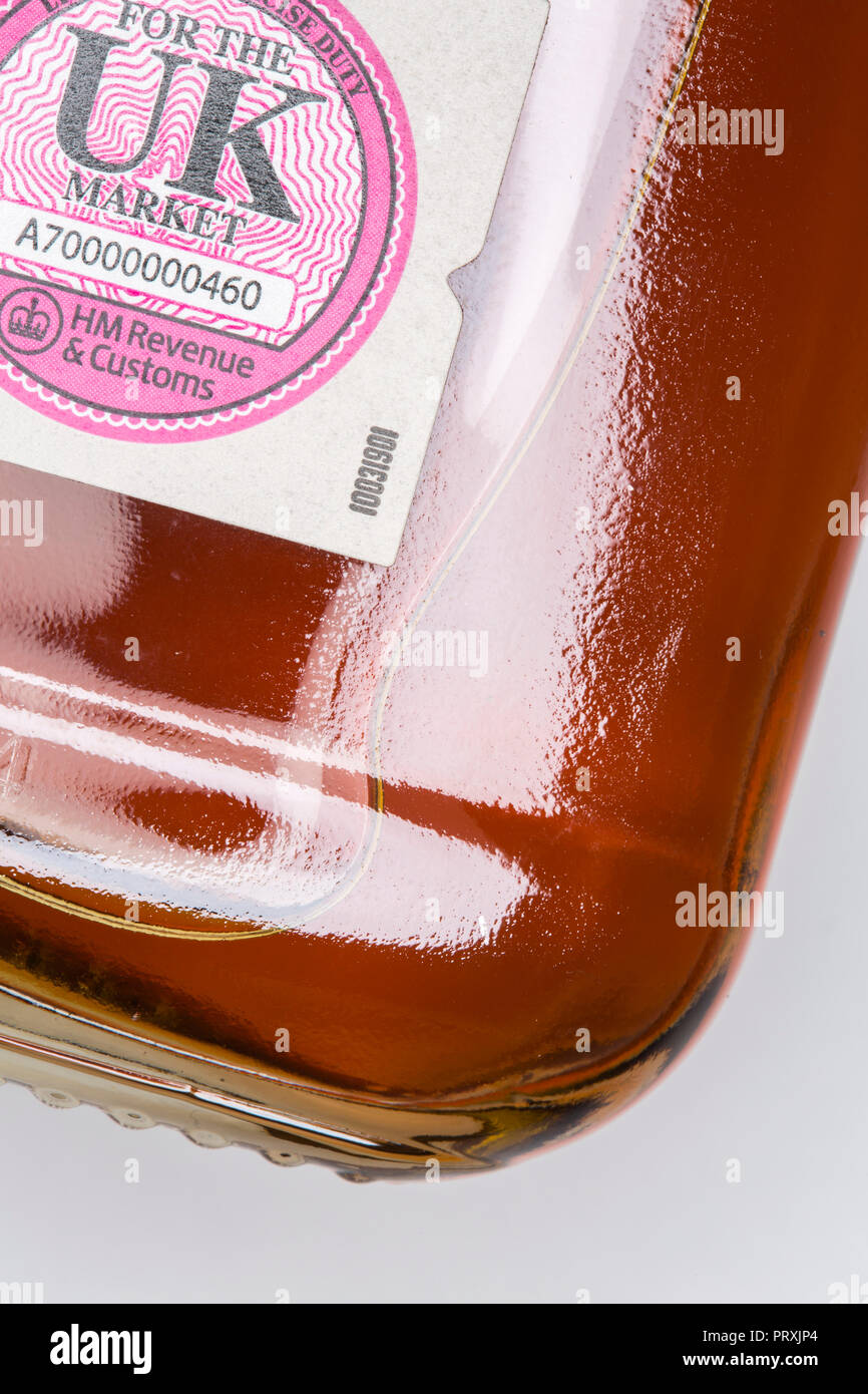 A bottle of amber coloured alcohol, whisky with a trapped bubble under ...