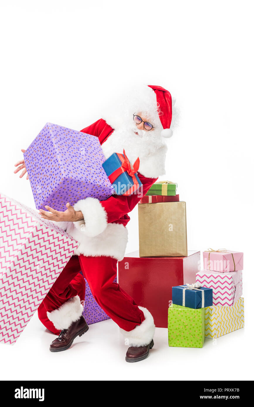 santa claus in eyeglasses dropping pile of gift boxes isolated on white ...