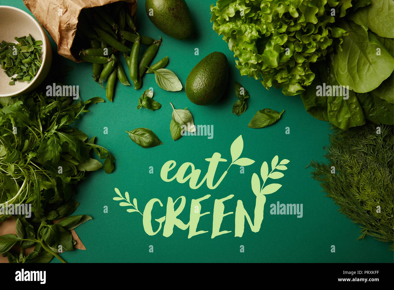 top view of different ripe vegetables on green surface with "eat green ...