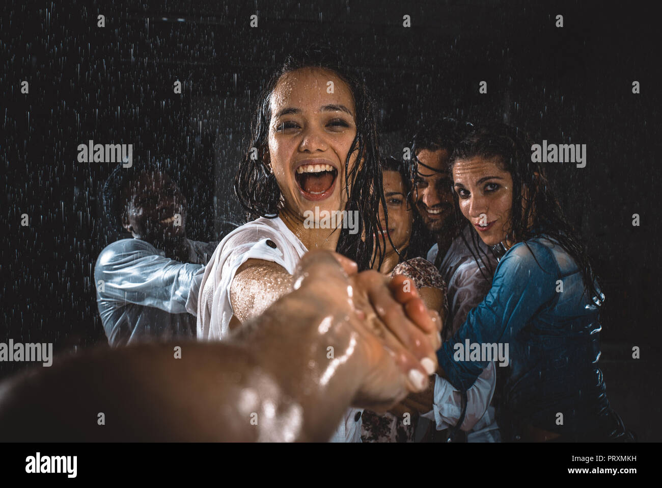 Groupof friends dncing in the rain Stock Photo - Alamy