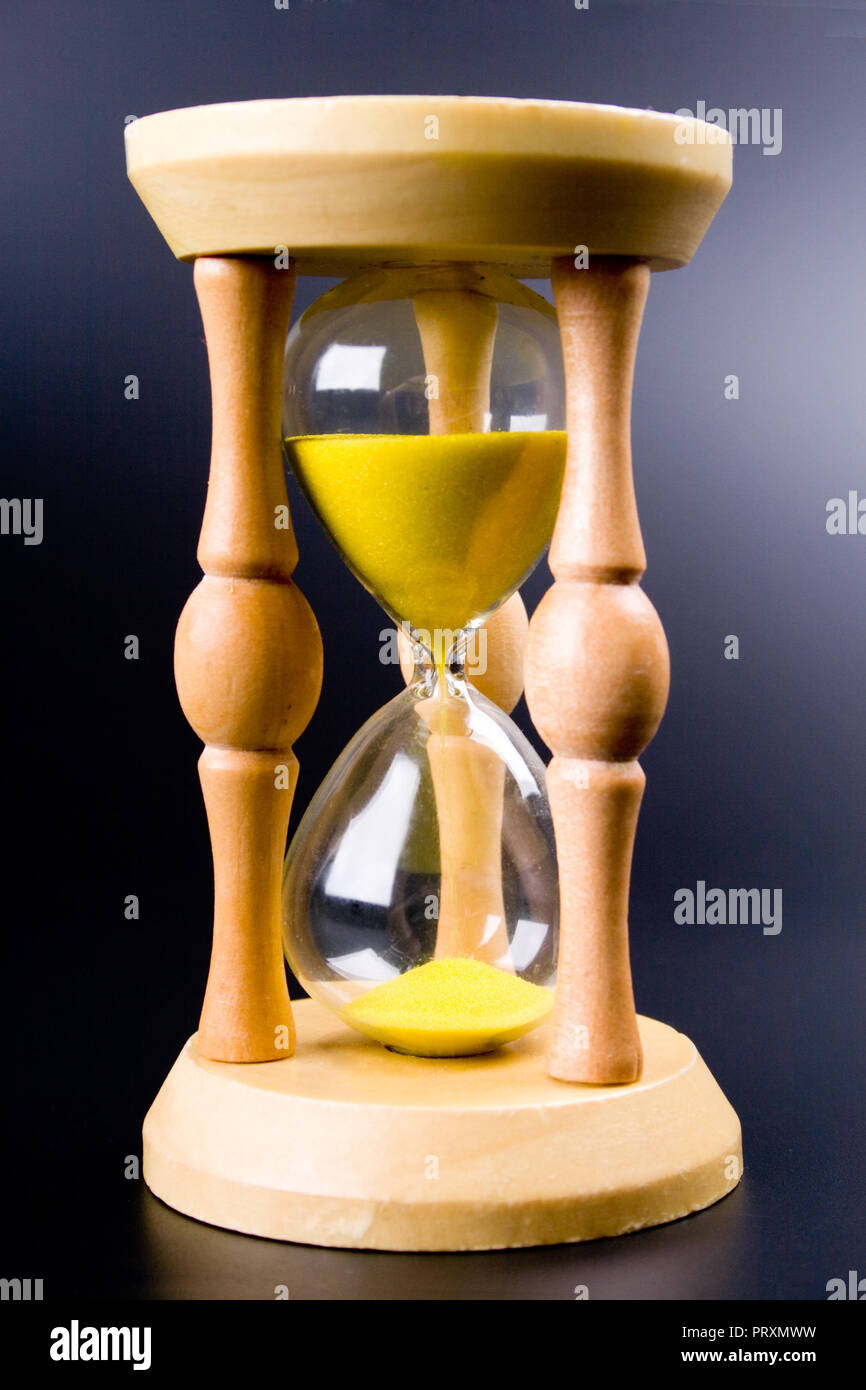 sand clock showing how is time passing on black background Stock Photo ...