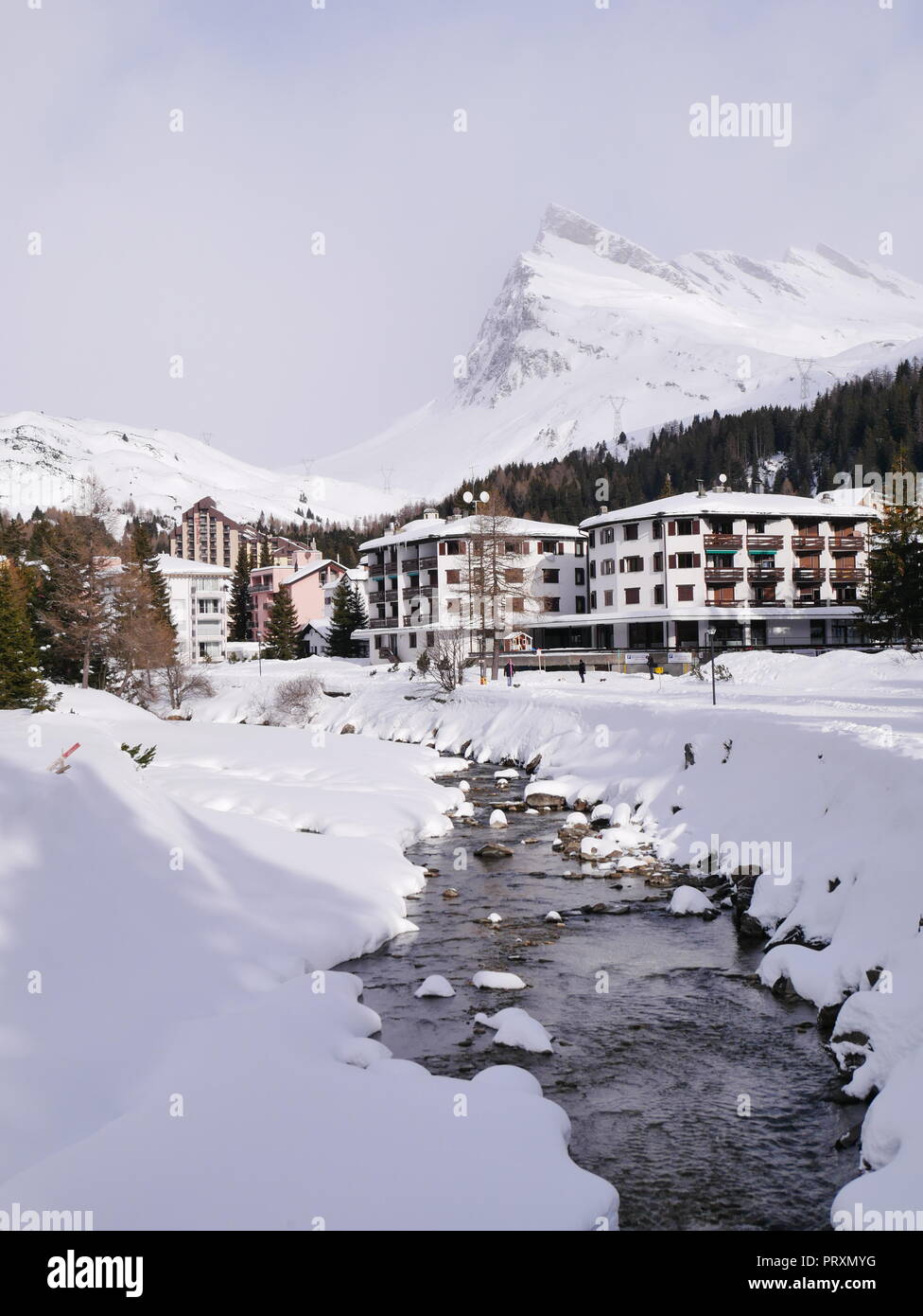 Alpine village of San Bernardino in the winter, with Moesa river in the ...