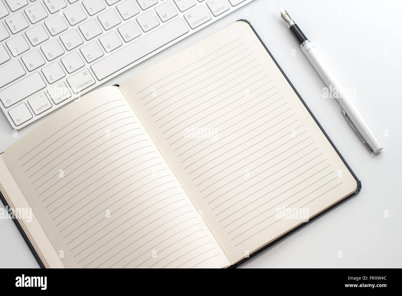 white table with notepad, keyboard and fountain pen. View from above ...