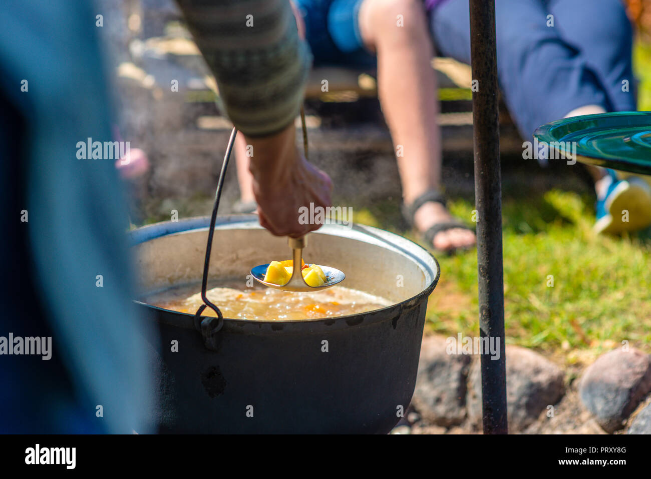 Cooking food in a pot on campfire. Summer camping concept Stock Photo ...