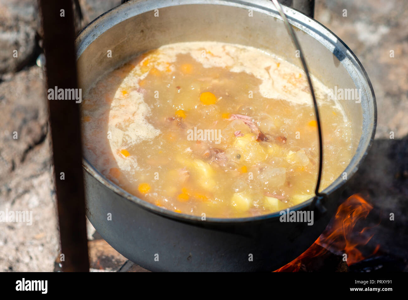Cooking food in a pot on campfire. Summer camping concept Stock Photo ...