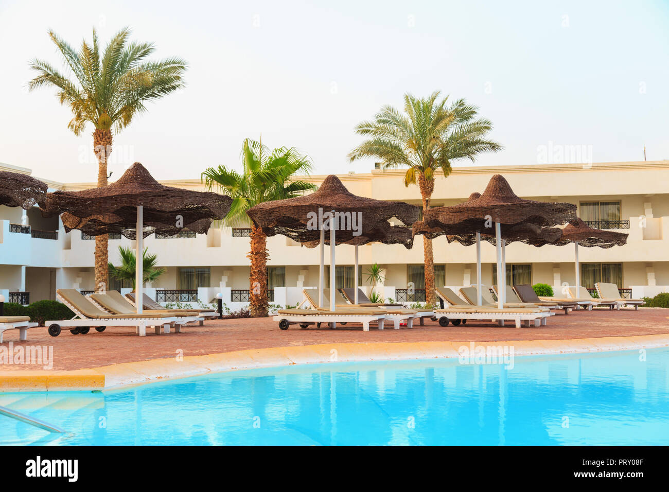 Pool side sunbeds umbrellas hi-res stock photography and images - Alamy