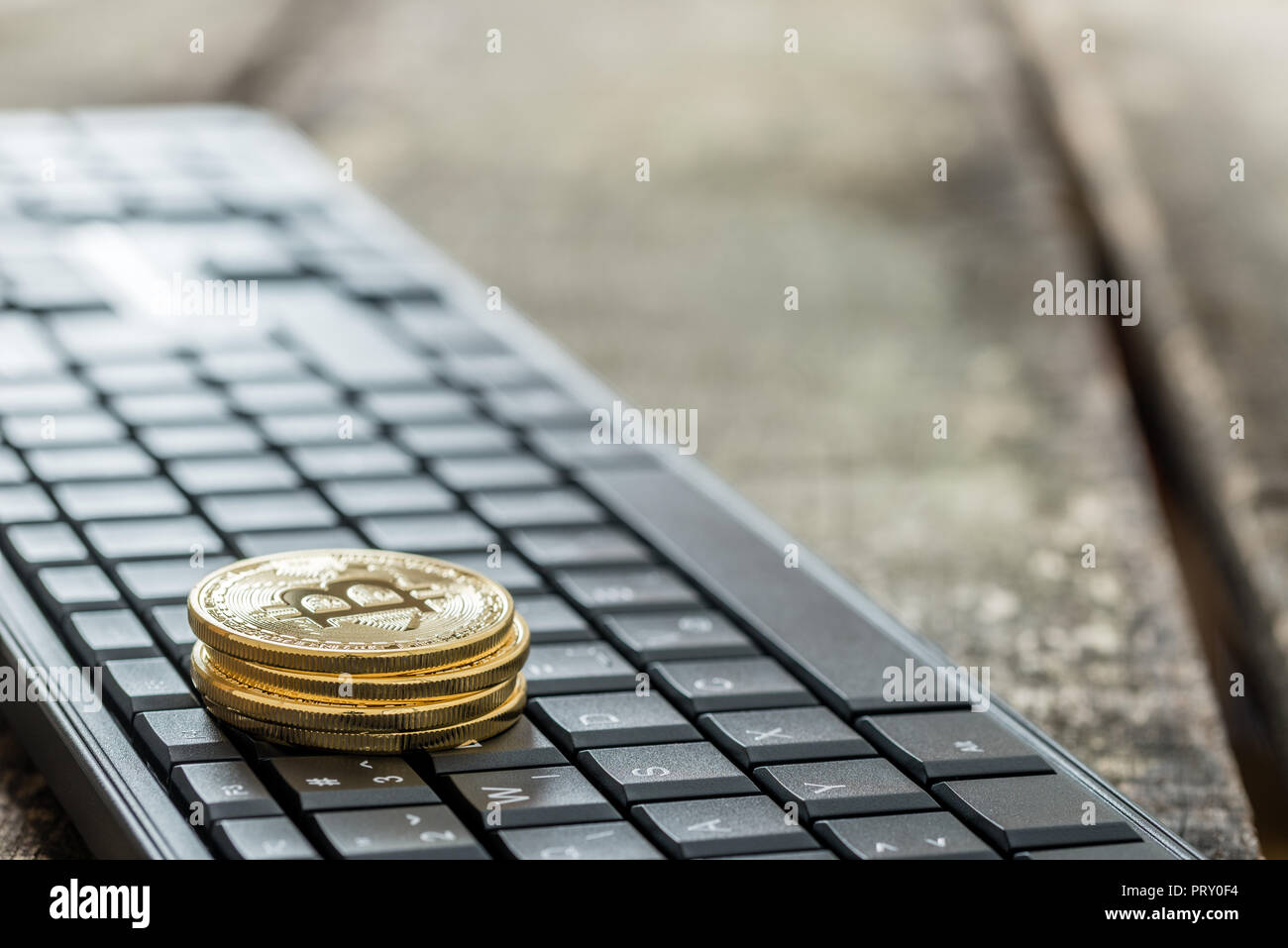 Pile of metal coins with Bitcoin sign over black computer keyboard on ...
