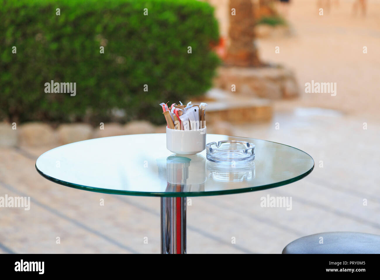 round empty glass table with ashtray and sugar sticks in the park Stock ...