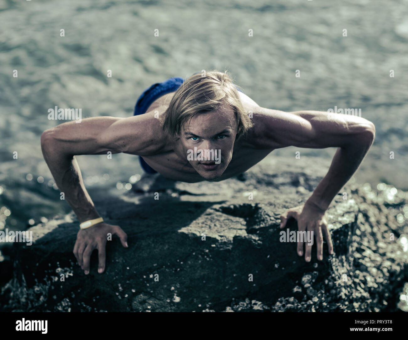 Healthy athlete doing push ups near the sea at sunset Stock Photo - Alamy