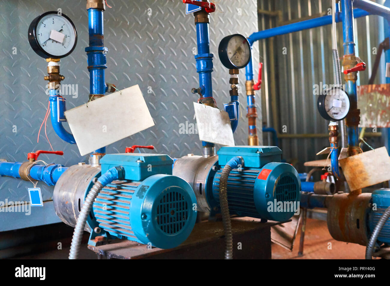 Old blue electric motor to the pump, valve and pressure gauge on the ...