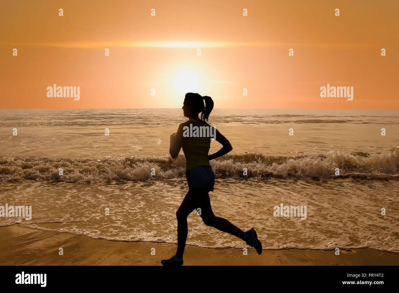 Beautiful landscape of woman running in the beach at sunset with a big ...
