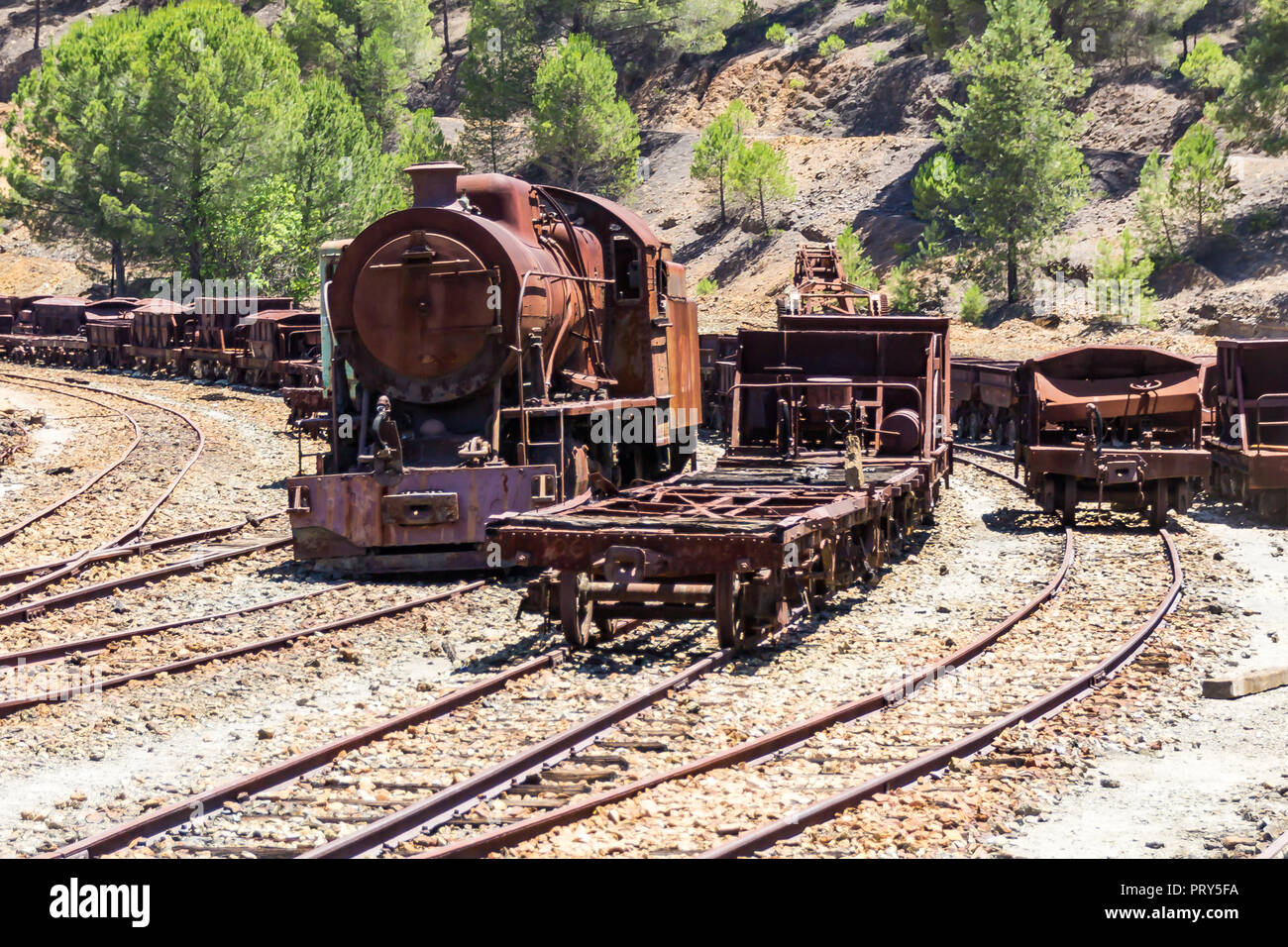 Rusty steam locomotive in railroad an train wagons Stock Photo - Alamy
