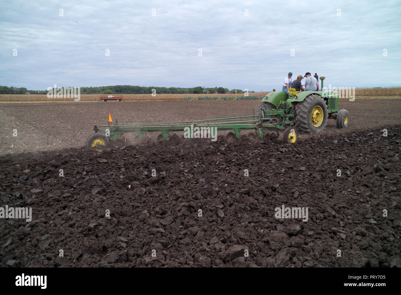 1966 John Deere tractor pulling a 7-bottom plow in an antique tractor ...