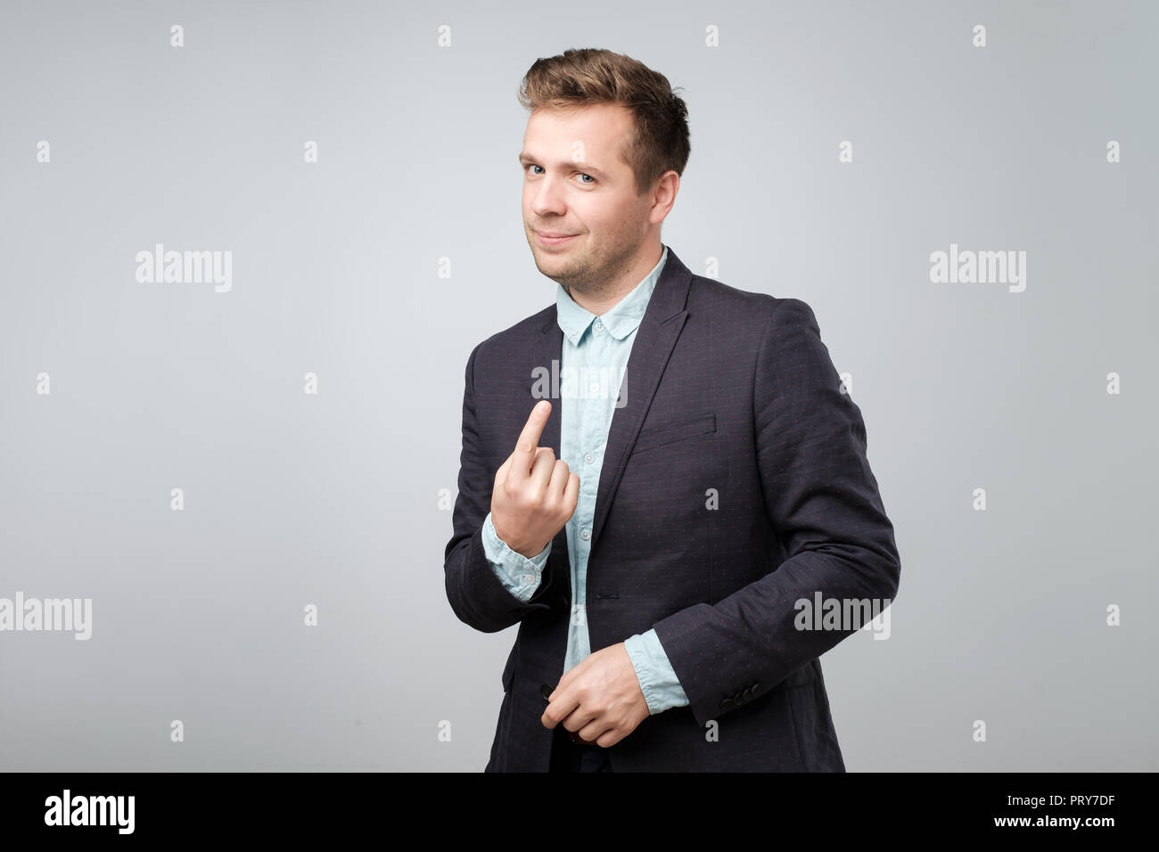 Studio portrait of playful mature adult showing come here gesture with ... Studio portrait of playful mature adult showing come here gesture with ...