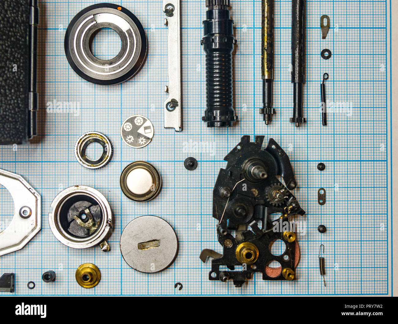 parts are completely disassembled old retro film SLR camera on graph ...