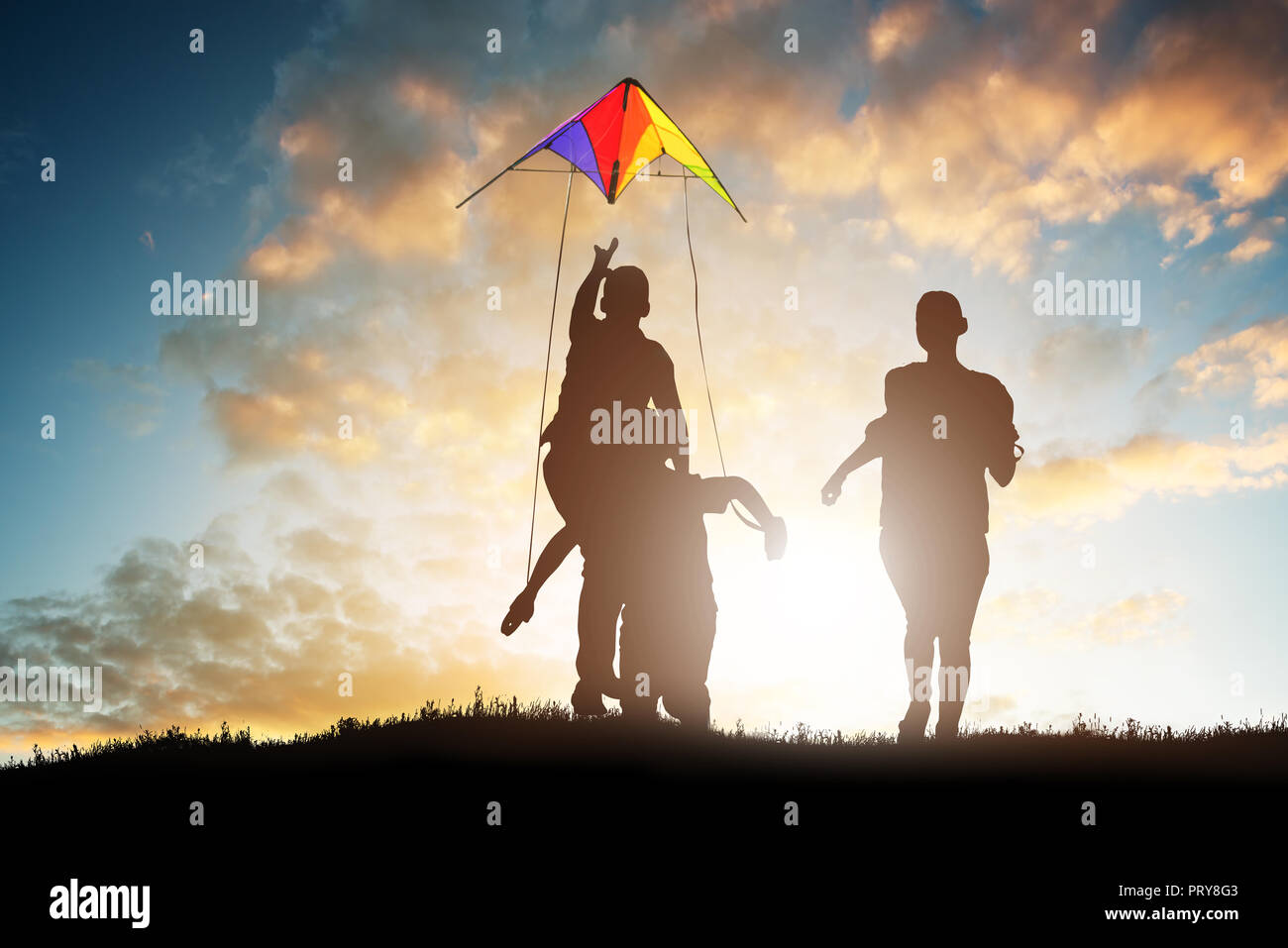 Silhouette Of Family Playing With The Colorful Kite At Sunset Stock ...