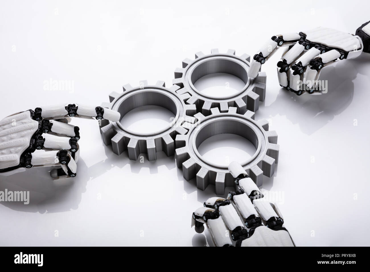 Robotic Hands Connecting Gears On White Background Stock Photo - Alamy