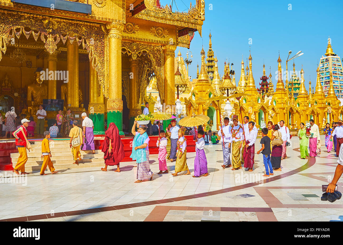 YANGON, MYANMAR - FEBRUARY 27, 2018: Buddhist devotees with golden ...
