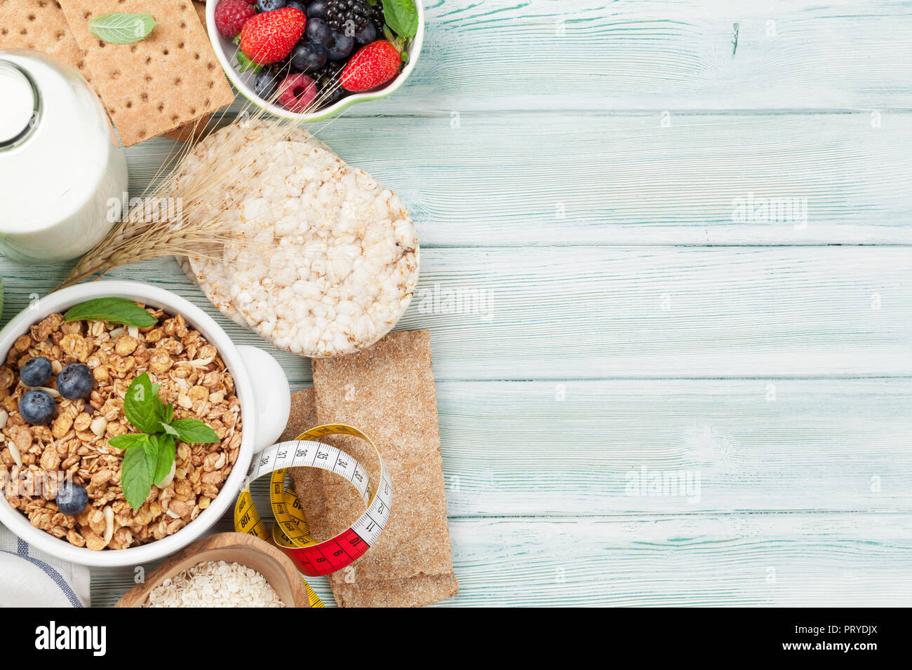 Healthy breakfast set with muesli, berries and milk. Top view with ...