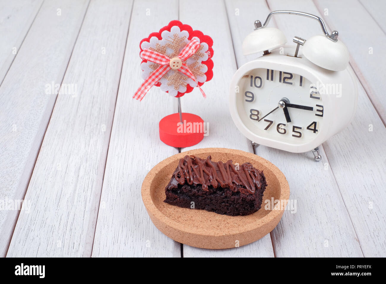 Alarm clock, note clipper and chocolate brownie with melted chocolate ...