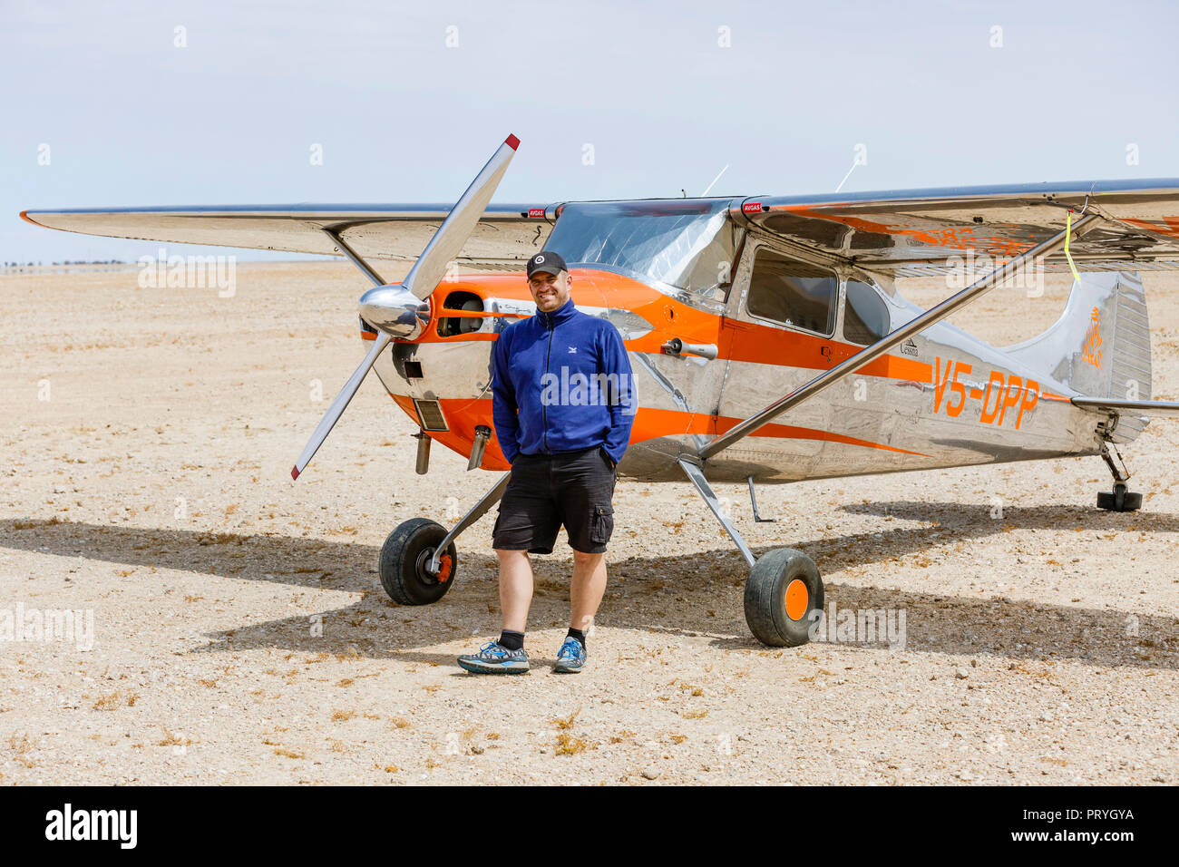 Man leaning against Cessna 170, Ganab Airfield, Namib Naukluft National ...