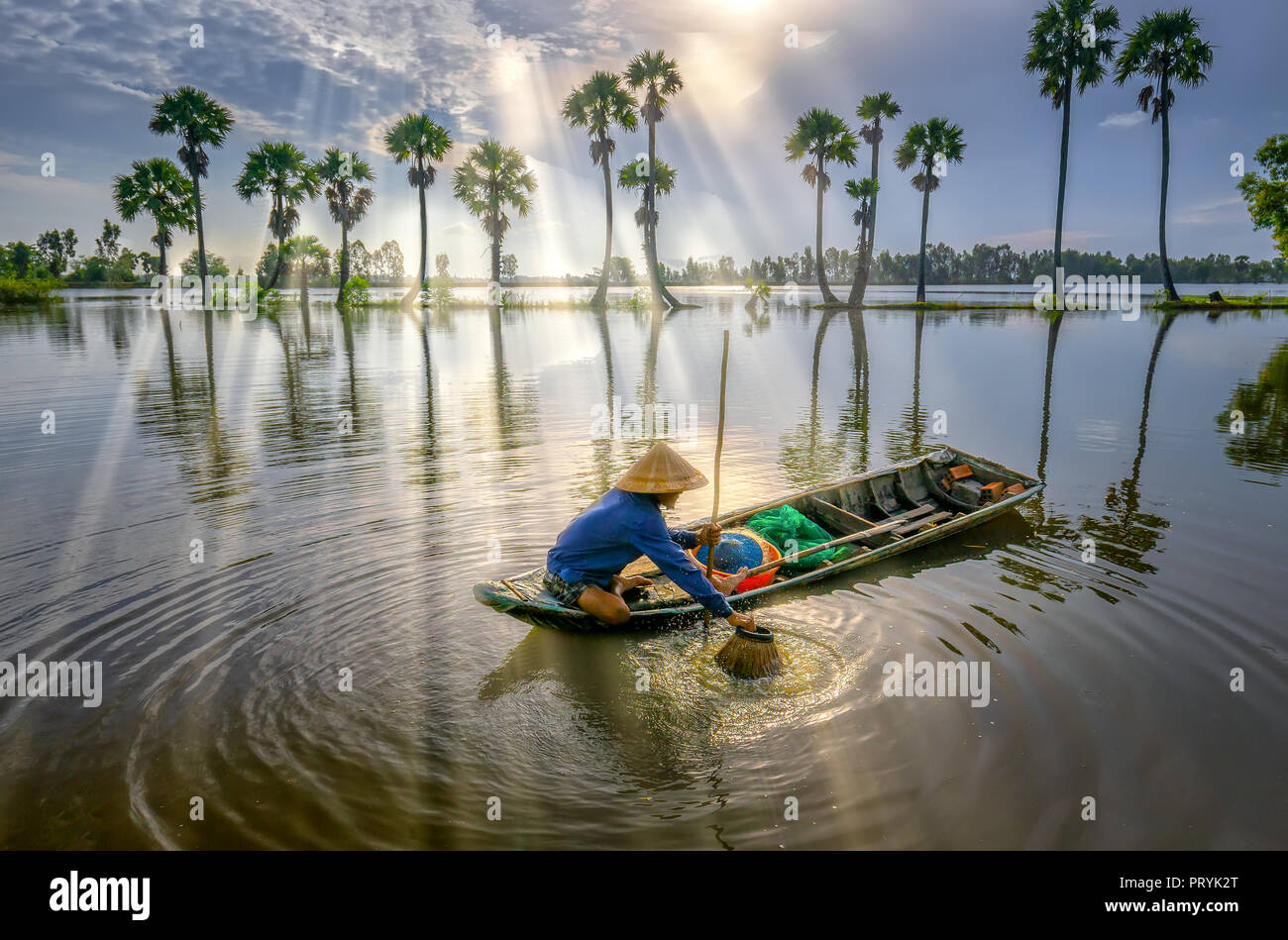 Unidentified fishers catch fish with bamboo tools in a lake when ...