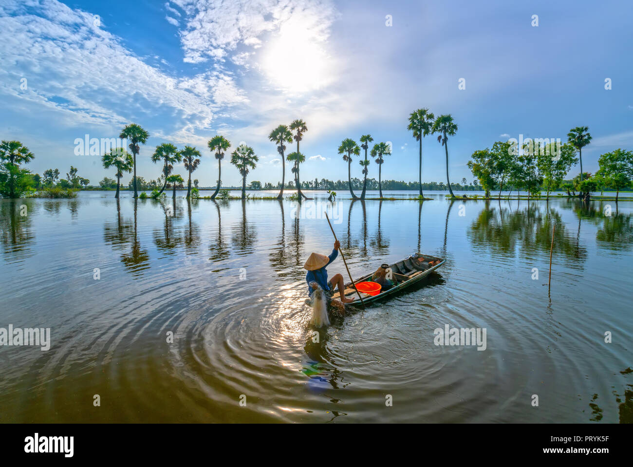 Unidentified fishers spread a net to catch fish in a lake when sunrises ...