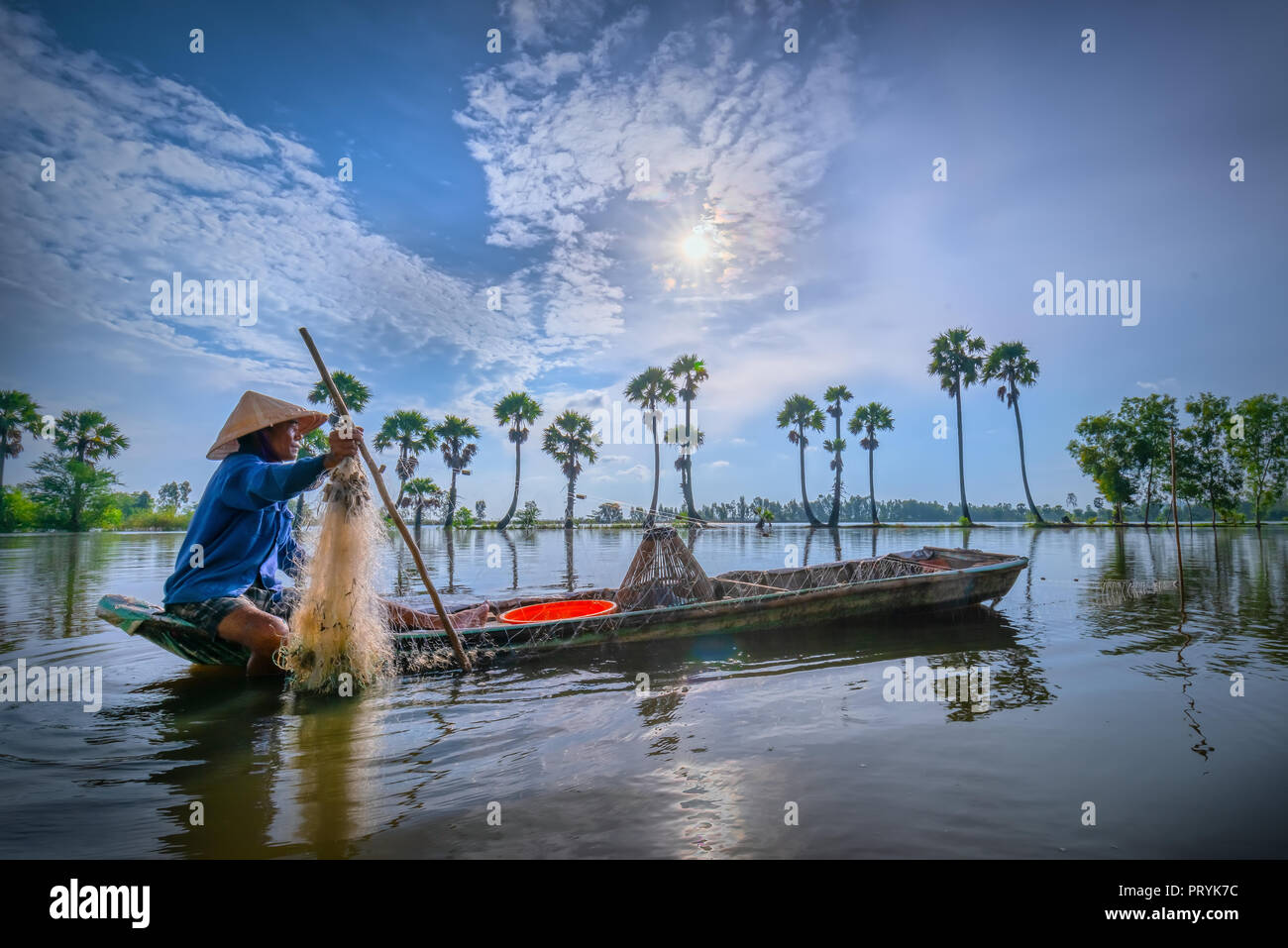 Unidentified fishers spread a net to catch fish in a lake when sunrises ...