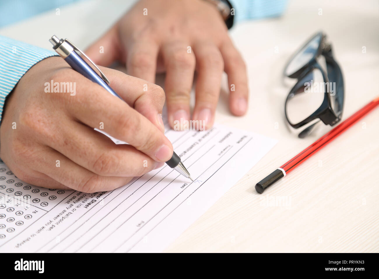 Picture of man is filling OMR sheet handing with pen Stock Photo - Alamy