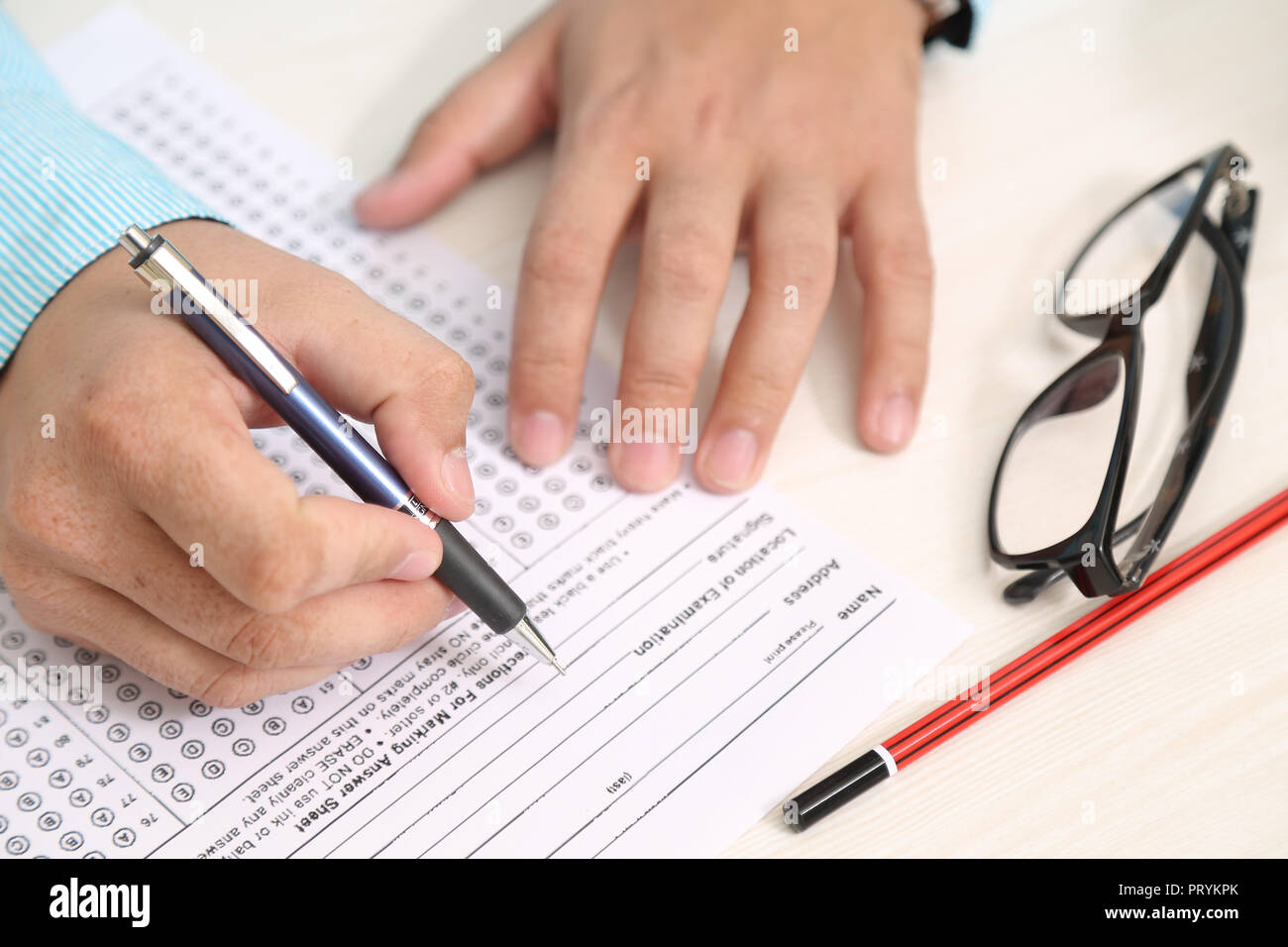 Top view of filling OMR sheet heading with pen. Picture of glasses and ...