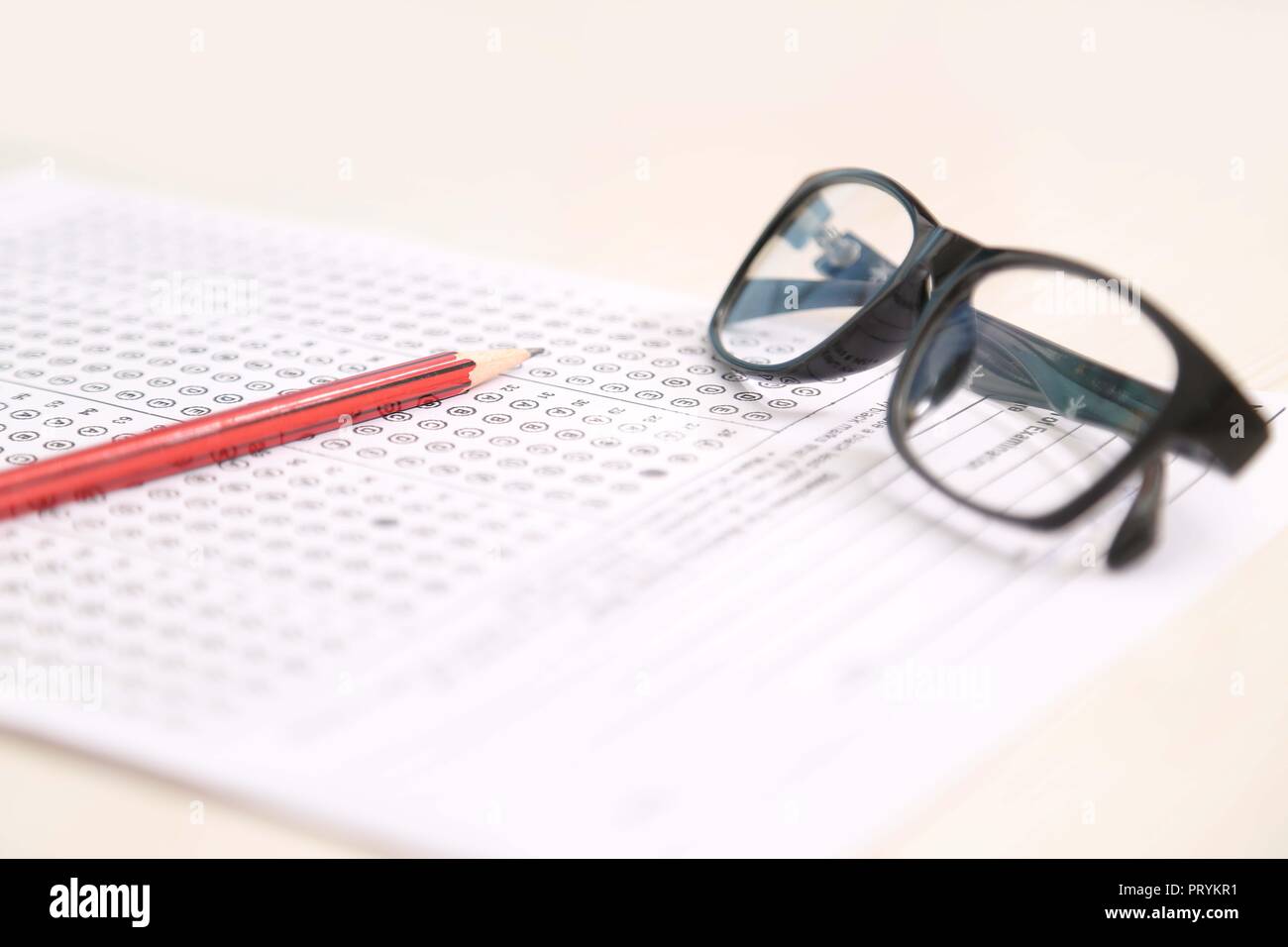 Picture of OMR sheet, pencil and glasses. Isolated on wooden background ...