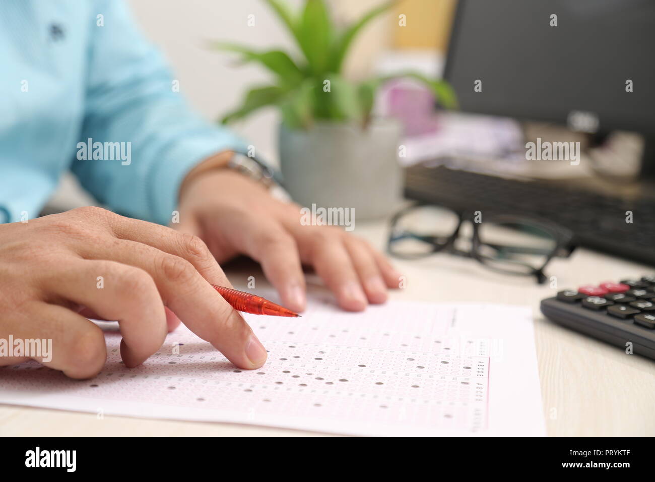Man is hand on the filled OMR sheet with pen. Picture of computer ...