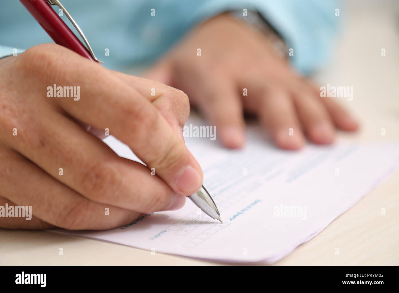 Man is filling form with pen Stock Photo - Alamy