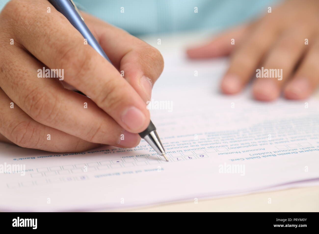 Picture of man is filling form with pen Stock Photo - Alamy