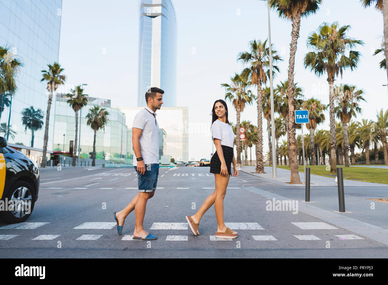 Young couple crossing street in the city, flirting Stock Photo - Alamy
