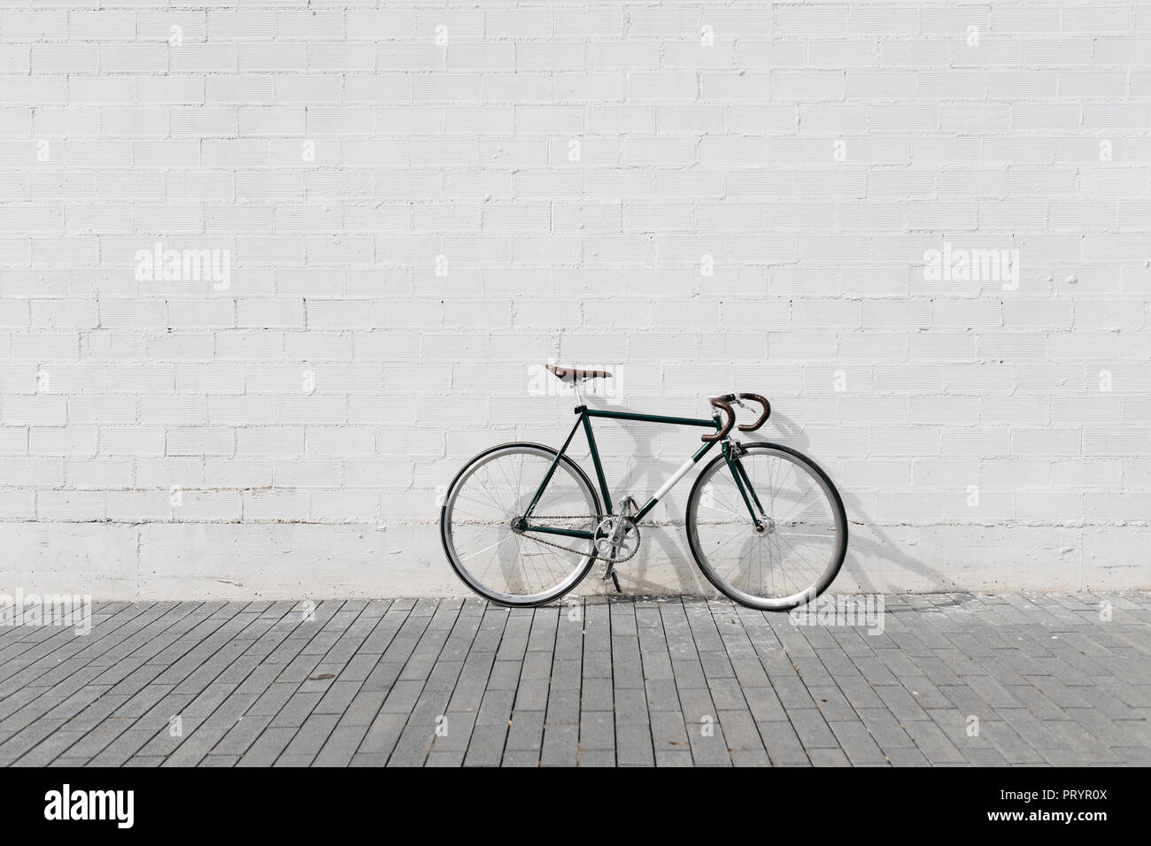 Racing cycle leaning against wall Stock Photo - Alamy
