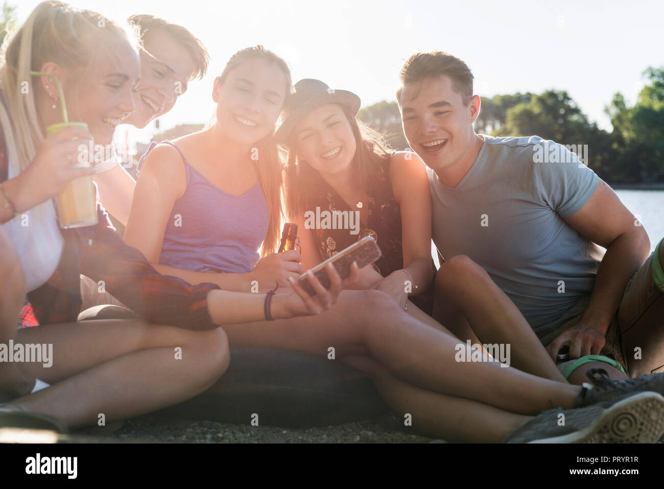 Group friends sitting outdoors hi-res stock photography and images - Alamy