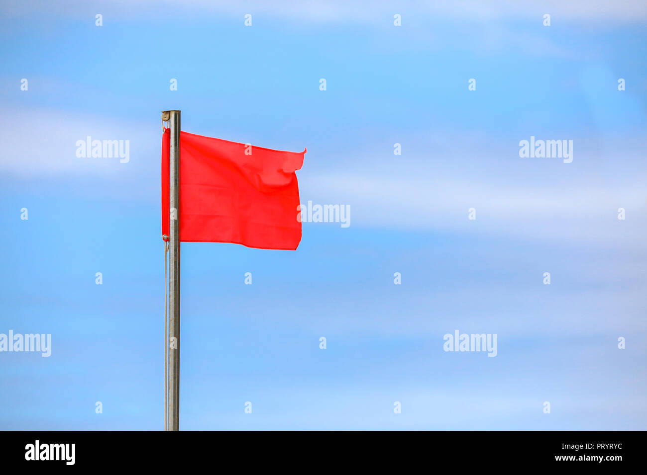 Red flag blowing in the wind Stock Photo - Alamy