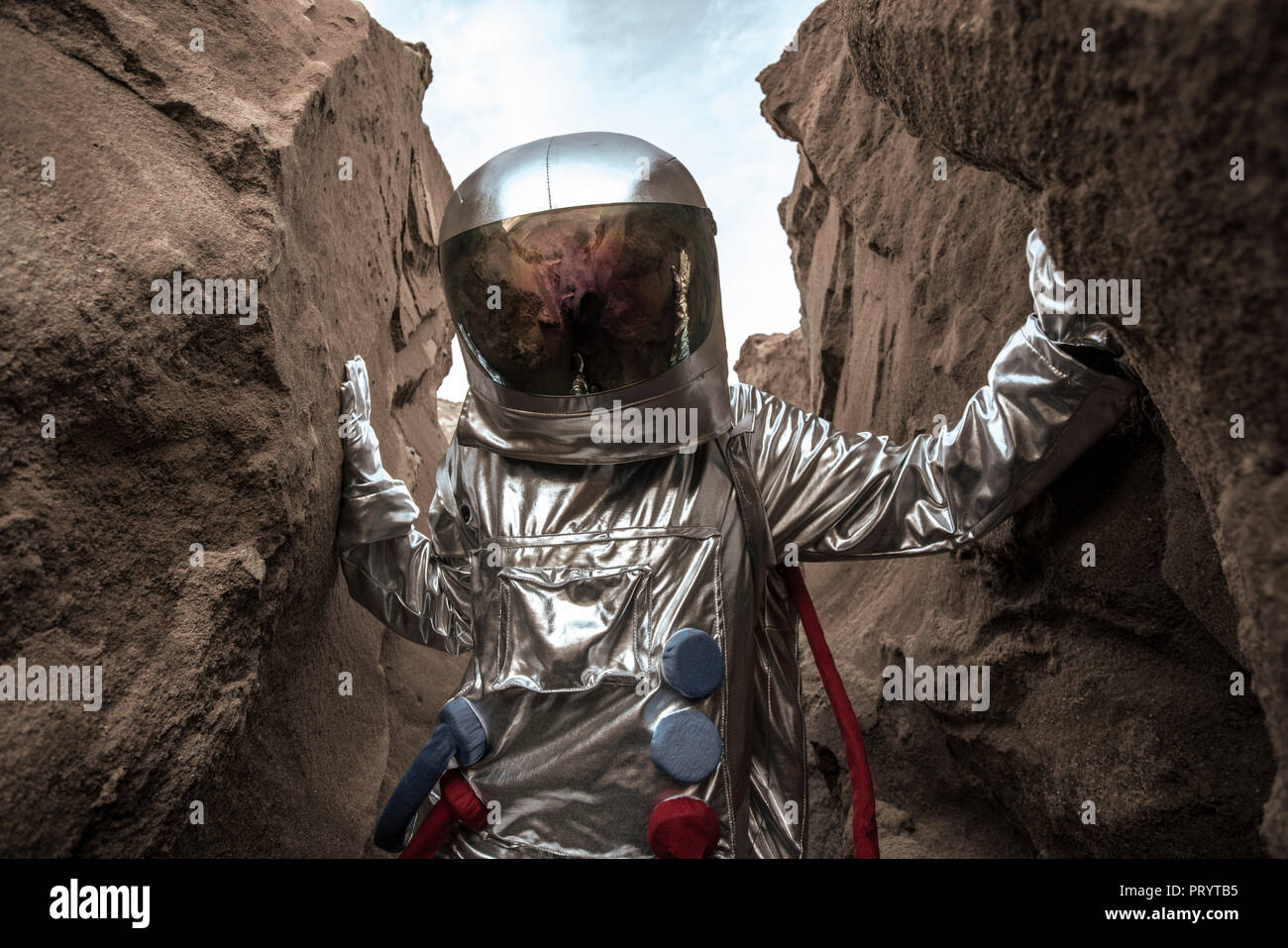 Spaceman exploring nameless planet, examining canyon Stock Photo - Alamy