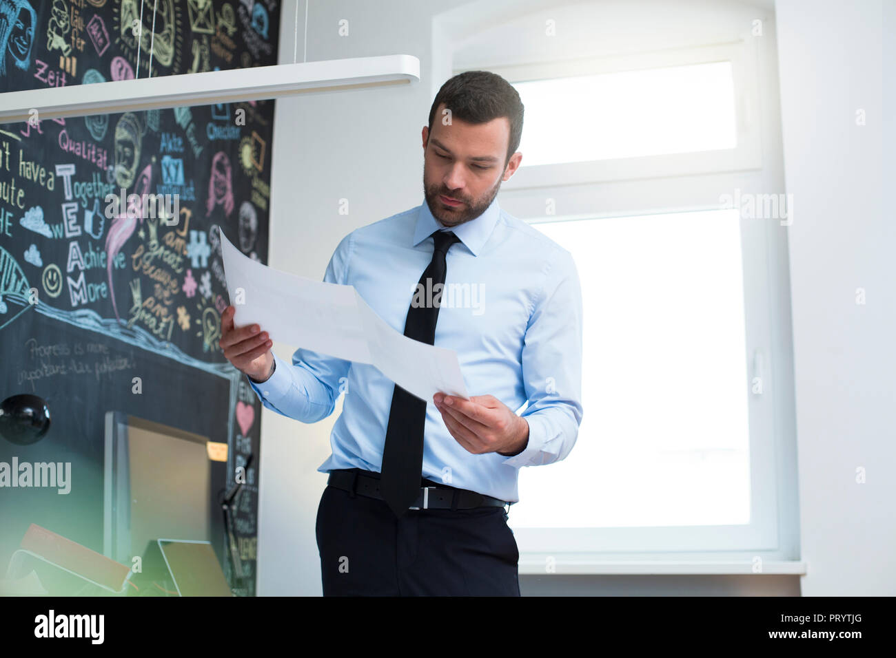 Serious creative man reading documents hi-res stock photography and ...