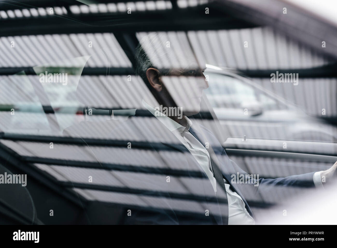 Businessman behind car window Stock Photo - Alamy