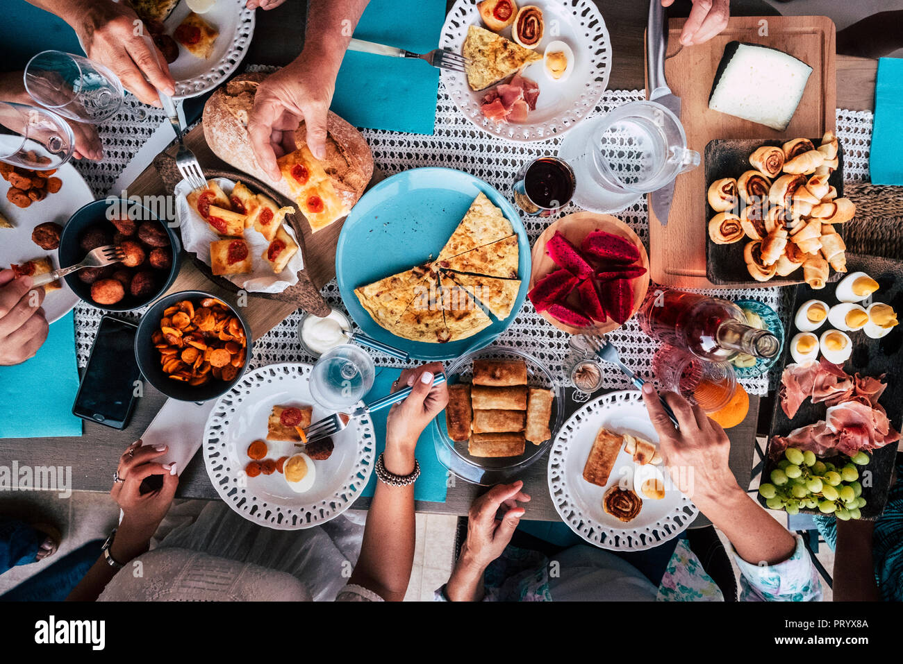 Above aerial view of group of friends having fun eating together at ...
