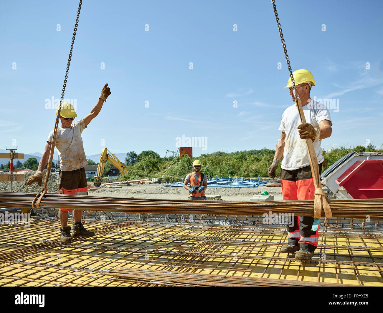 Workers on construction site preparing iron rods Stock Photo - Alamy